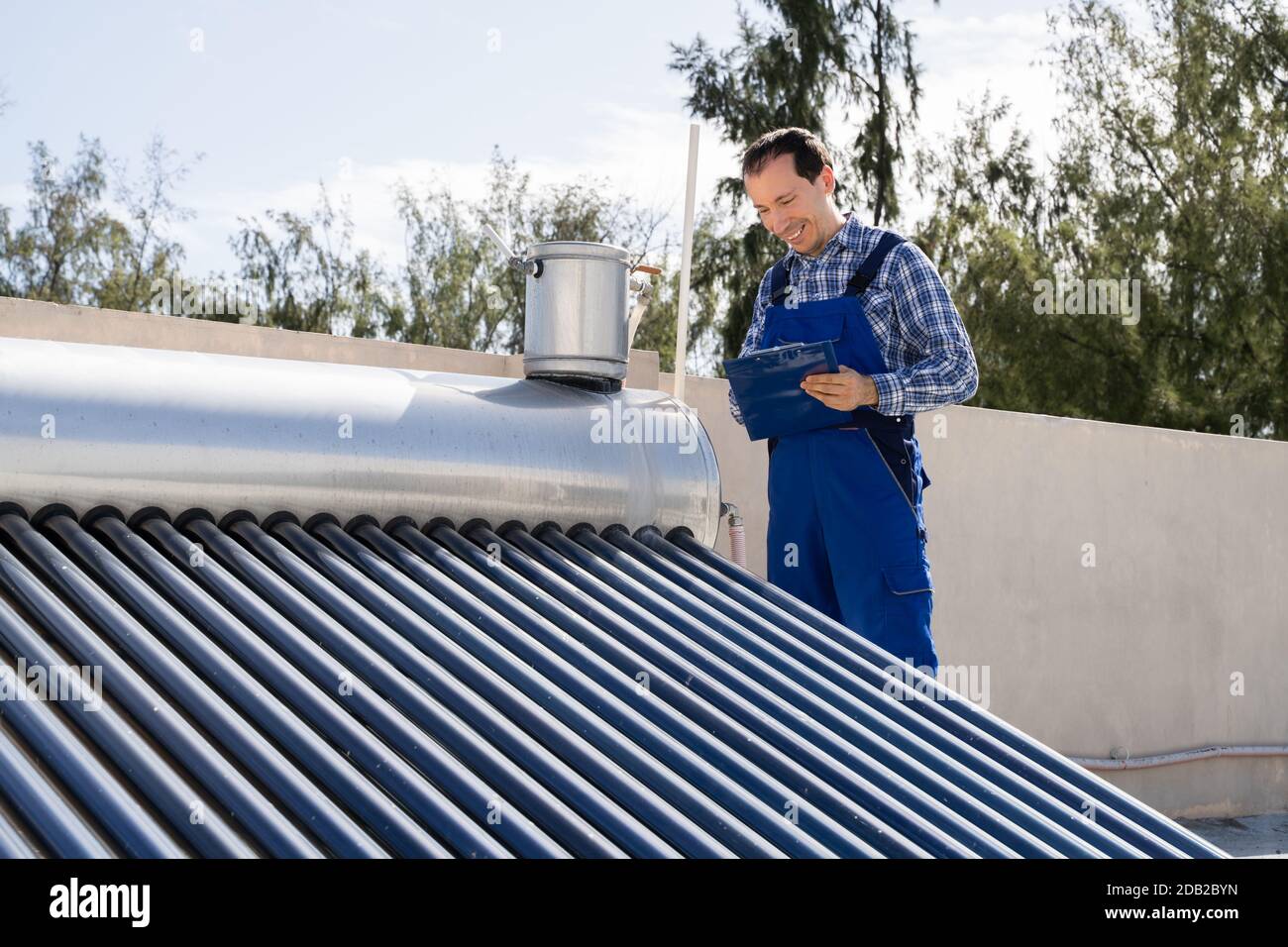Male Plumber Doing Solar Energy Boiler Inspection Stock Photo - Alamy