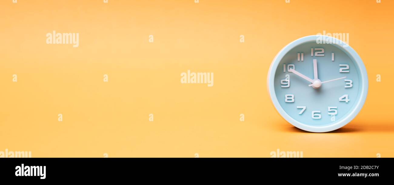 Photo Of Clock Showing 12 O'clock On Yellow Background Stock Photo - Alamy