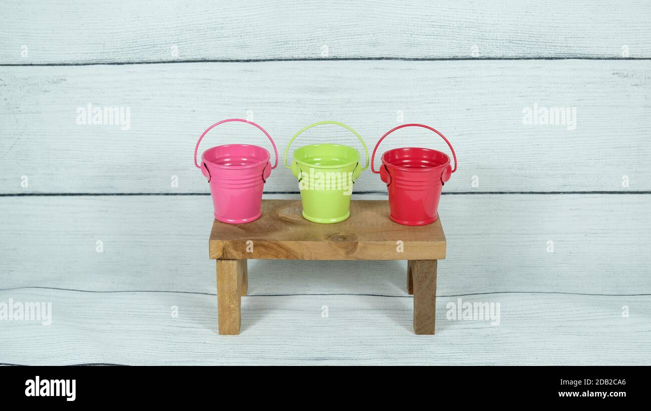 Color mini buckets on wood decor Stock Photo - Alamy