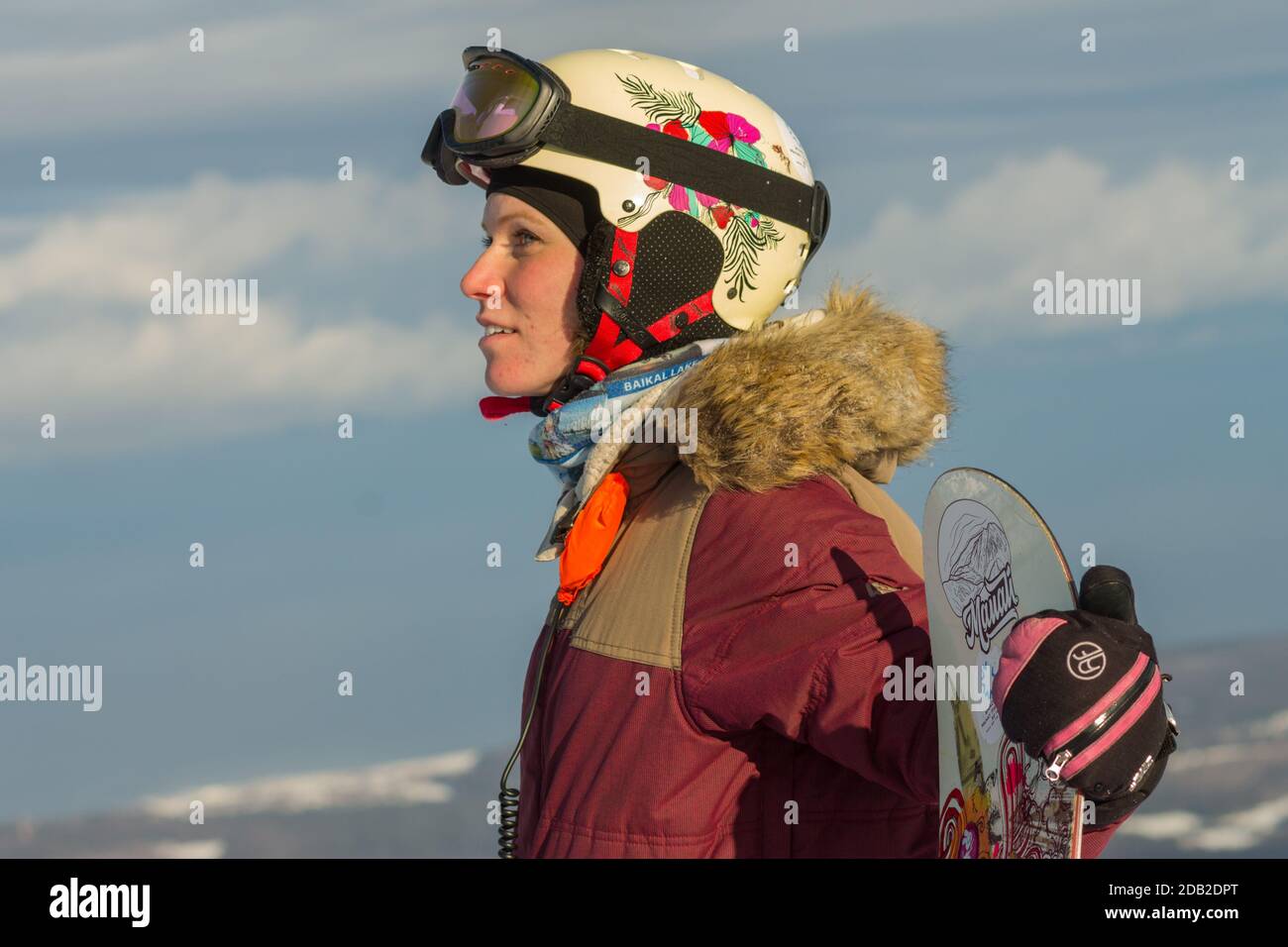 portrait of a snowboarder woman freerider in helmet in snowy mountains ...
