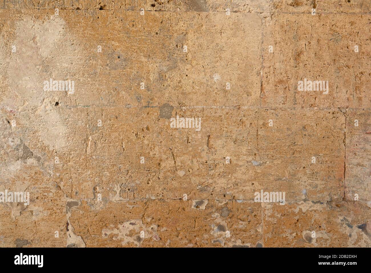 wall of yellow rectangular stones with cement, fragment of ancient ...