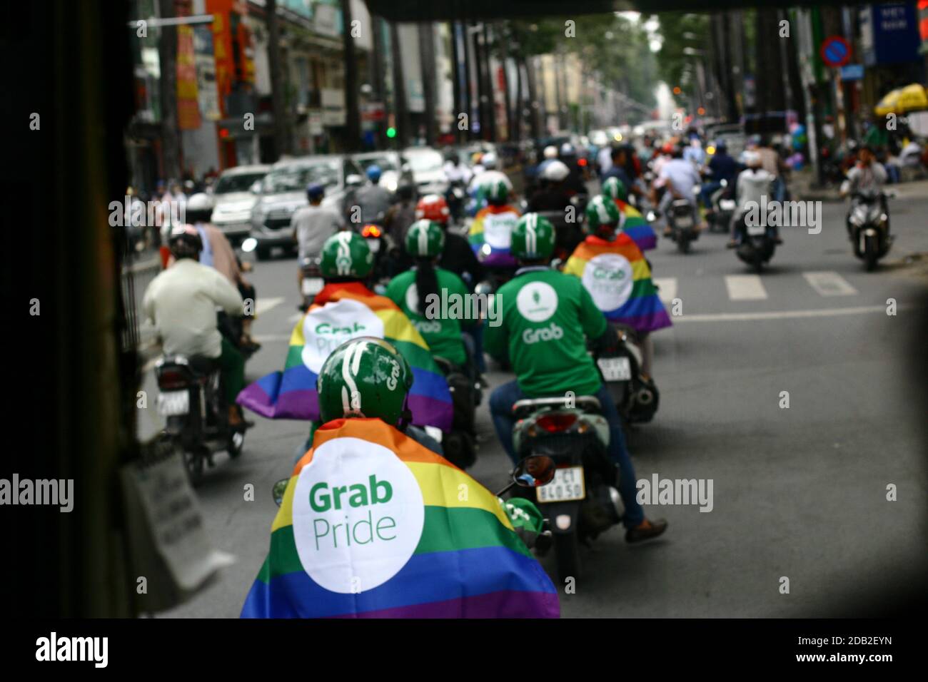 group of Taxi grabbike grab drivers in traffic with rainbow flag ...