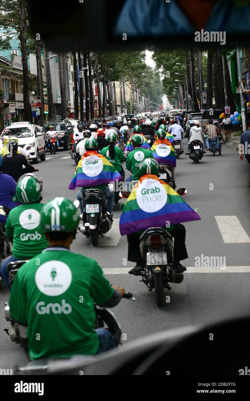 group of Taxi grabbike grab drivers in traffic with rainbow flag ...