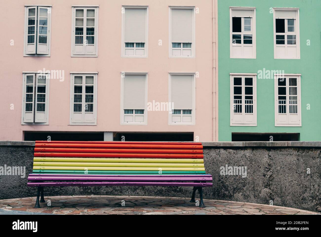 A colorful wooden bench near an old building Stock Photo - Alamy