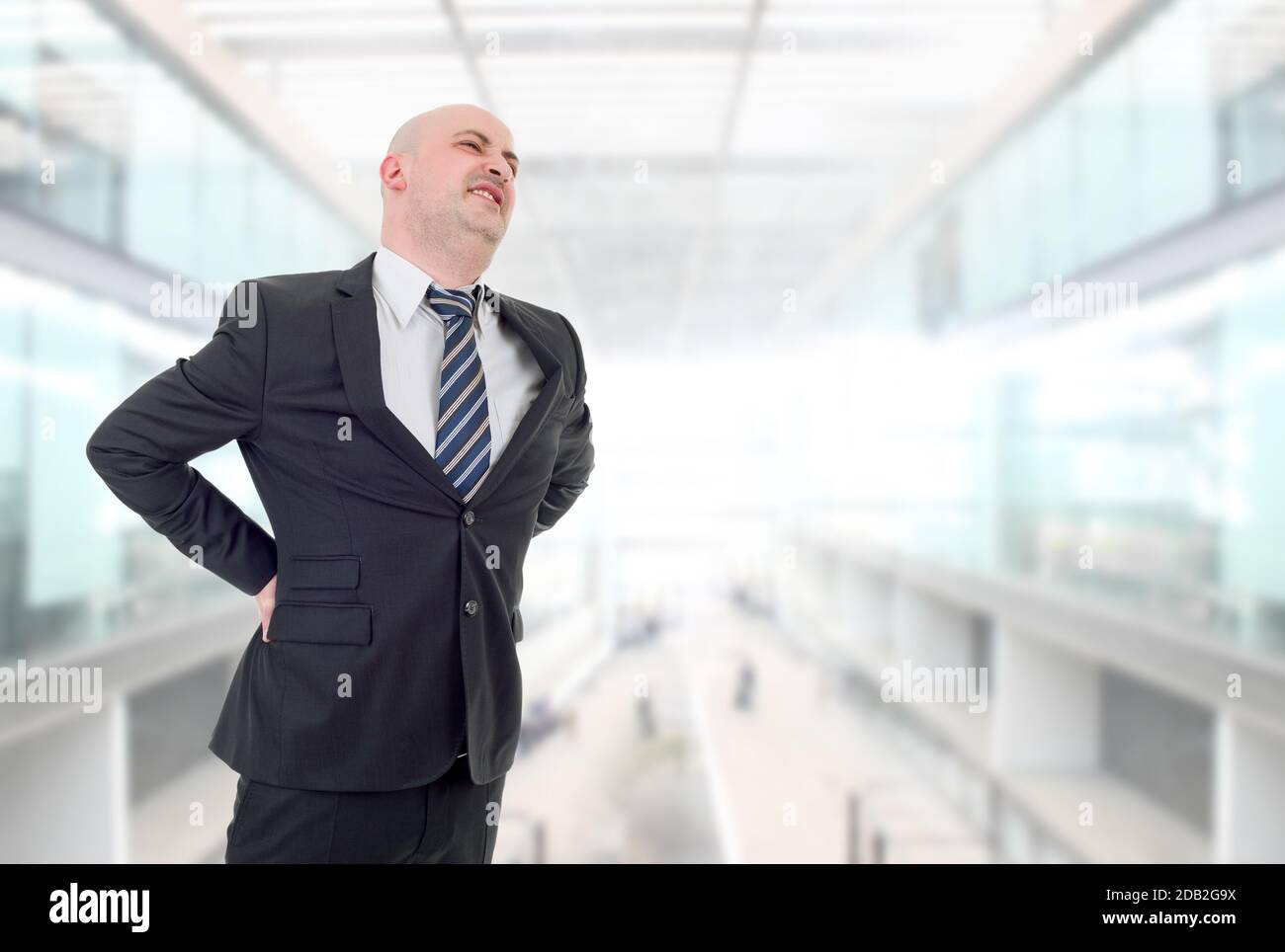 Young businessman with strong back pain, at the office Stock Photo - Alamy