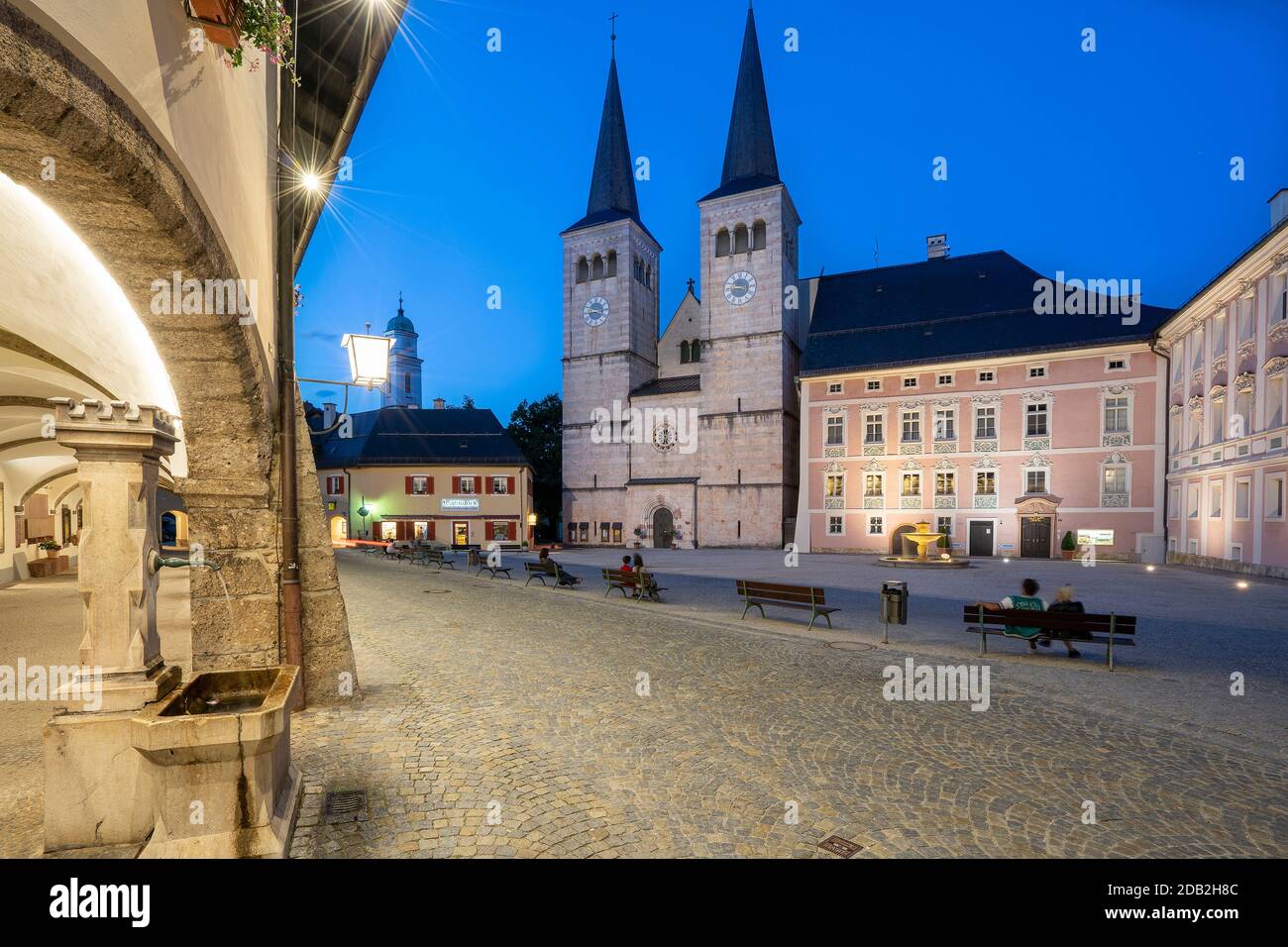 The castle square of Berchtesgaden at night with fountain, church ...