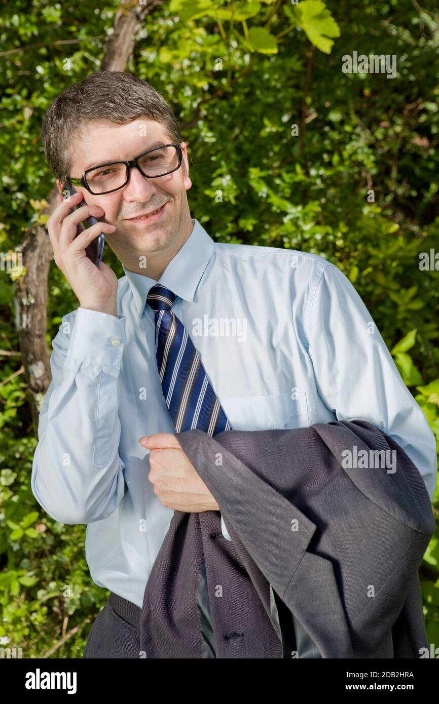 Happy businessman outdoor talking through mobile phone Stock Photo - Alamy
