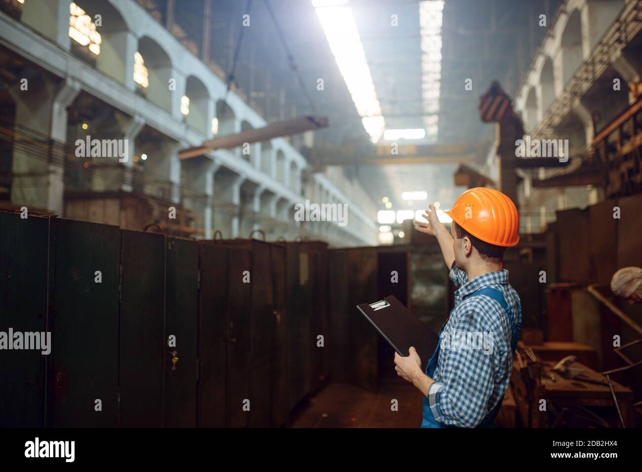 Master shows thumbs up to crane operator on metal factory. Metalworking ...