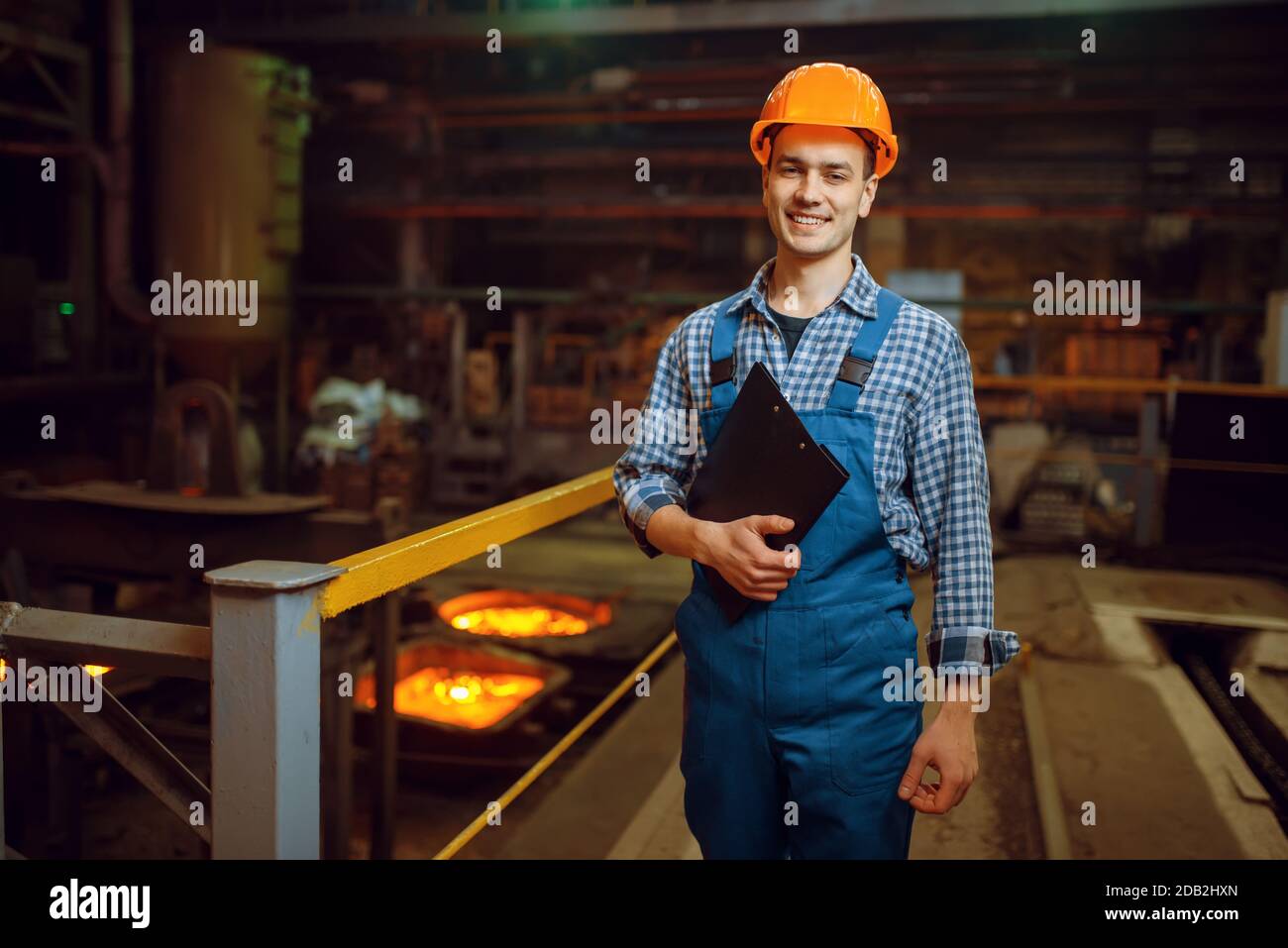 Master in helmet at furnace with liquid metal, steel factory ...