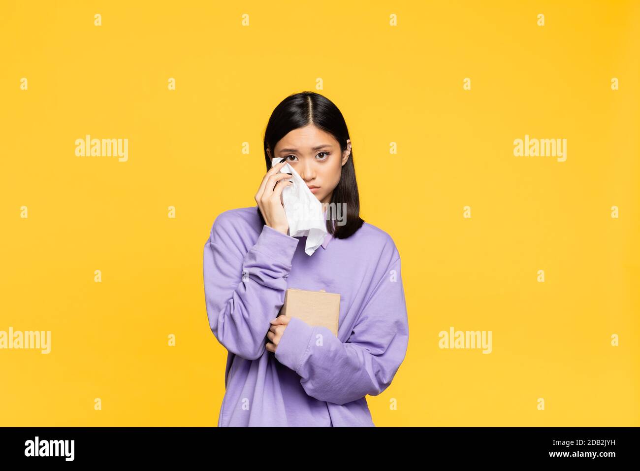 sad asian woman holding tissue box and napkin while crying isolated on ...