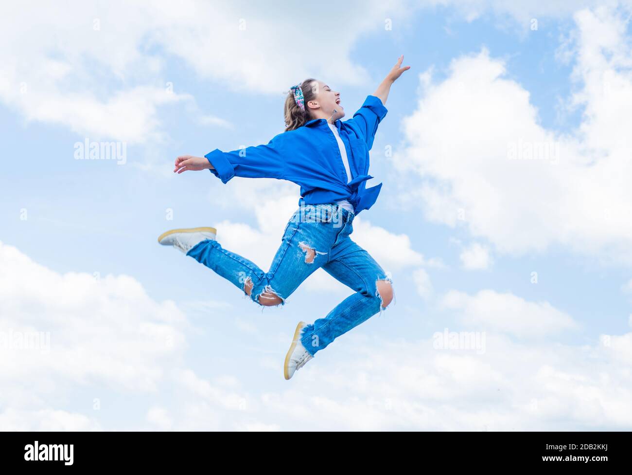 teen girl wearing casual fashion clothes jumping high on sky background ...