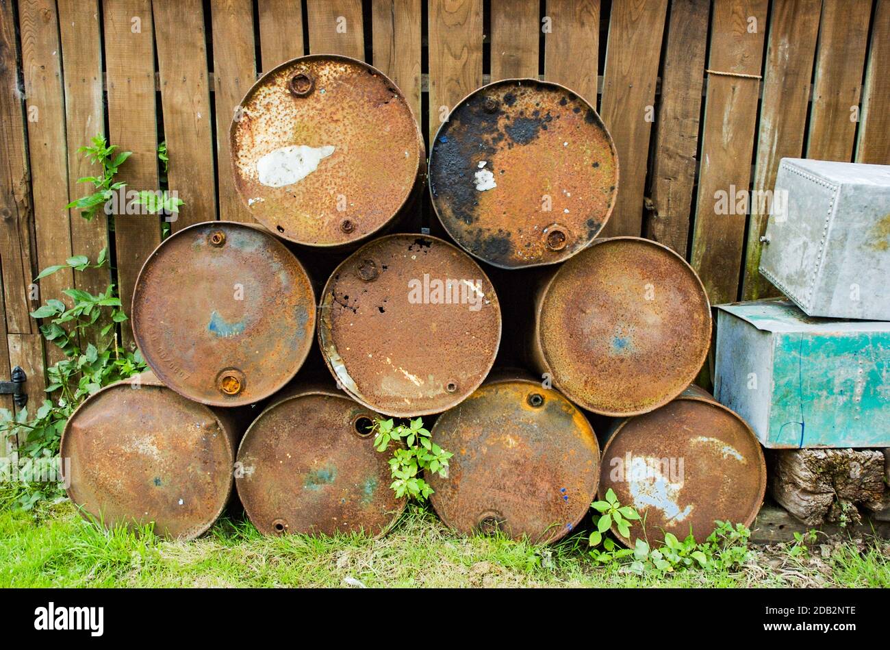 Rusty old oil barrels stacked in a boat yard in Norfolk, England, UK ...