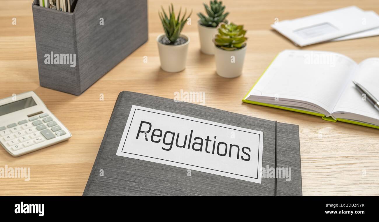 A folder on a desk with the label Regulations Stock Photo - Alamy