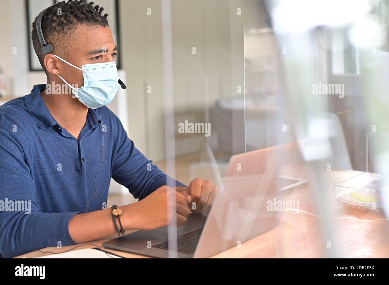 Office-worker in open-space office protected by plexiglas, wearing ...