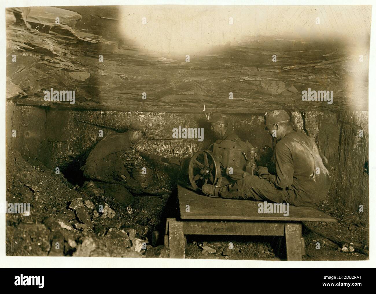 Brown Mine. Man digging coal by machinery low ceiling: scales off and ...