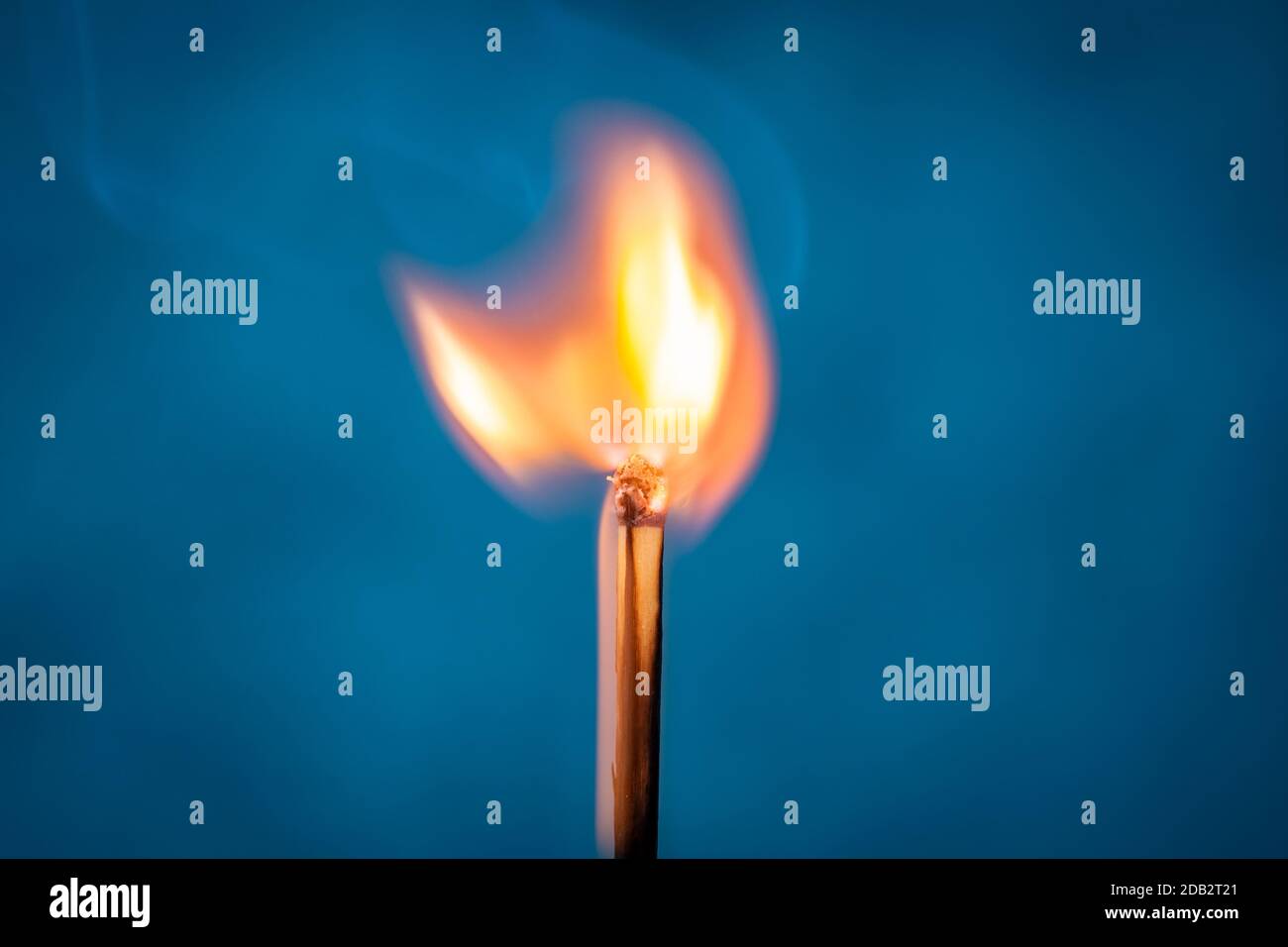 Ignition of a match, with smoke on blue background. A beauty of burning ...