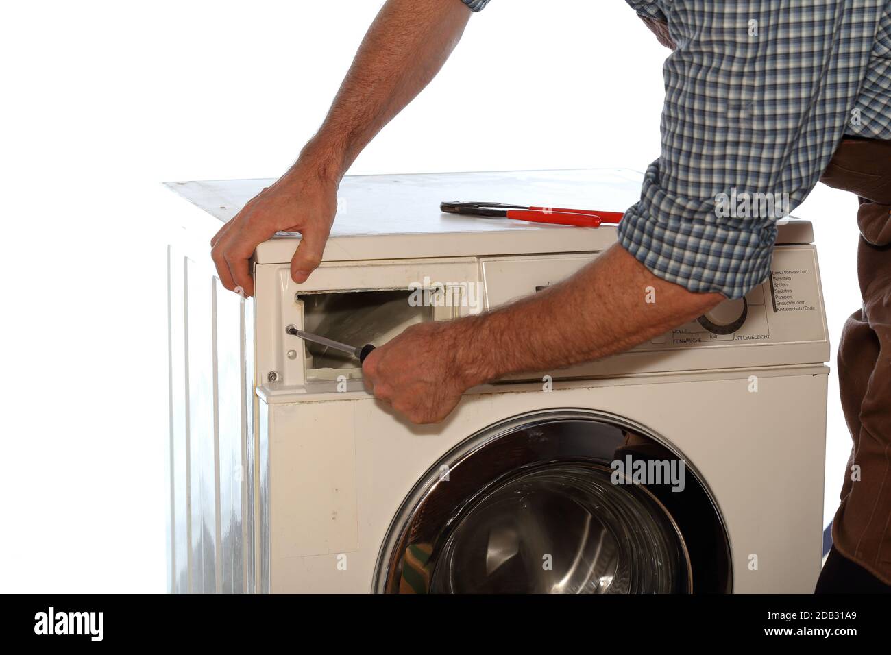 worker is repairing a washing machine with tools Stock Photo - Alamy
