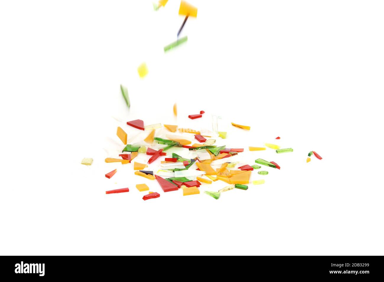 Colorful glass shards scattered across white surface Stock Photo - Alamy