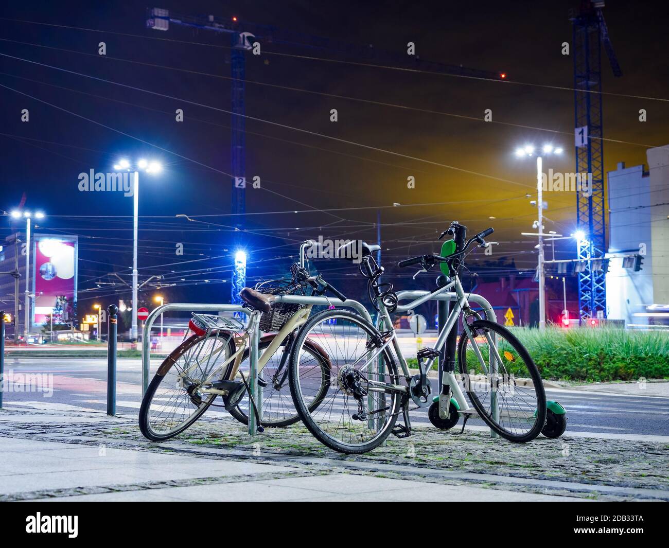 two old bikes left at night on a city street Stock Photo - Alamy