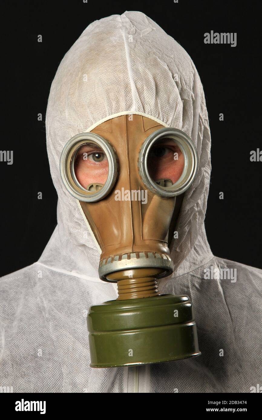 A vertical shot of a male wearing a protective suit and a gas mask ...