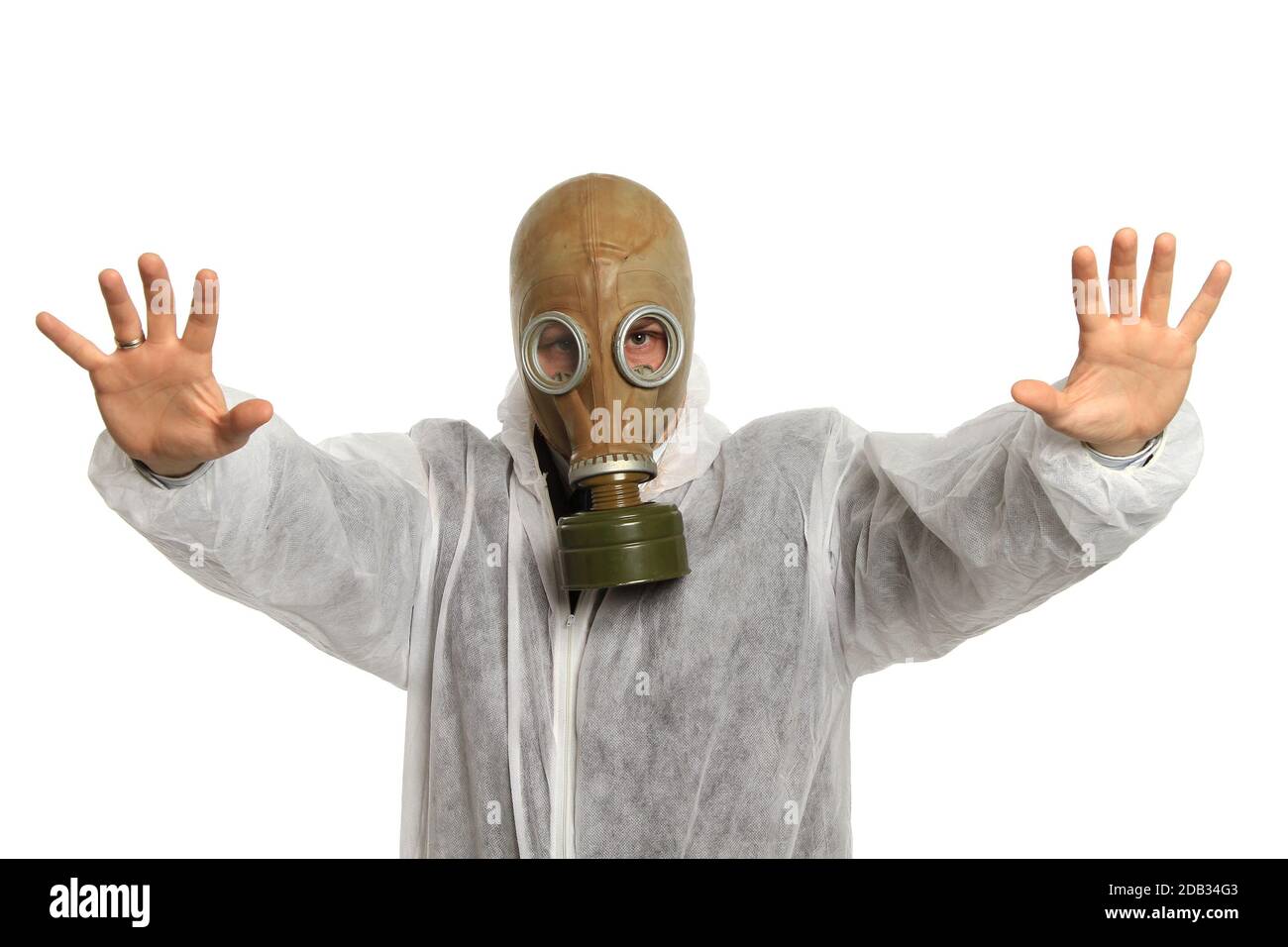 A man in full protective clothing wearing a gas mask and raising hands ...