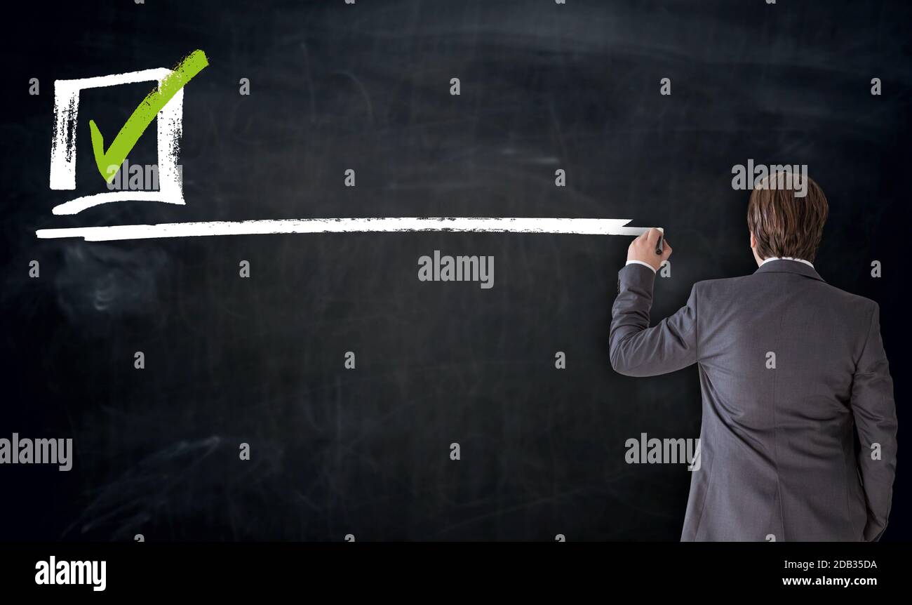 Businessman writing checkbox on blackboard concept Stock Photo - Alamy