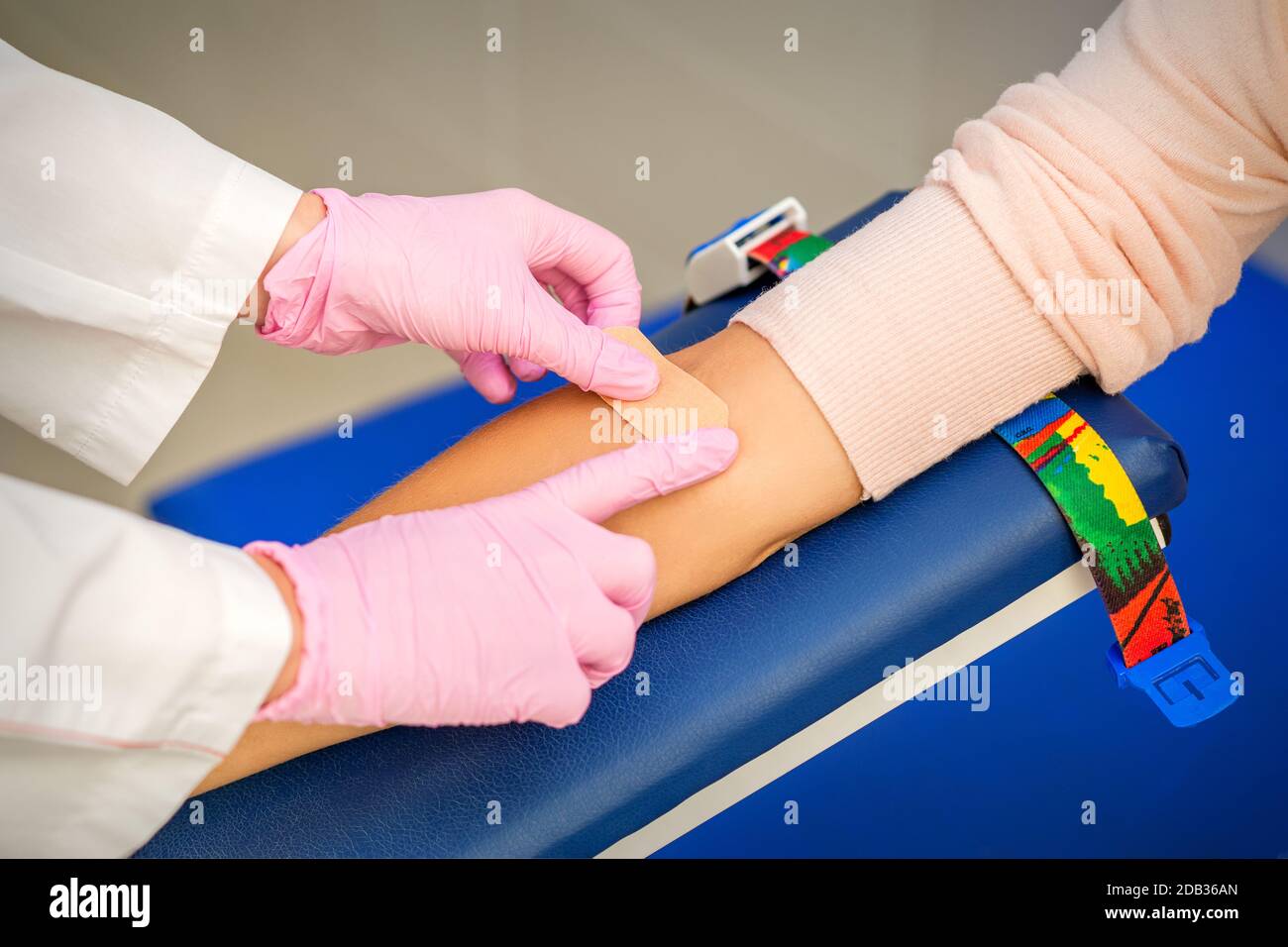 Close up of nurse hand applying adhesive plaster on arm of patient ...