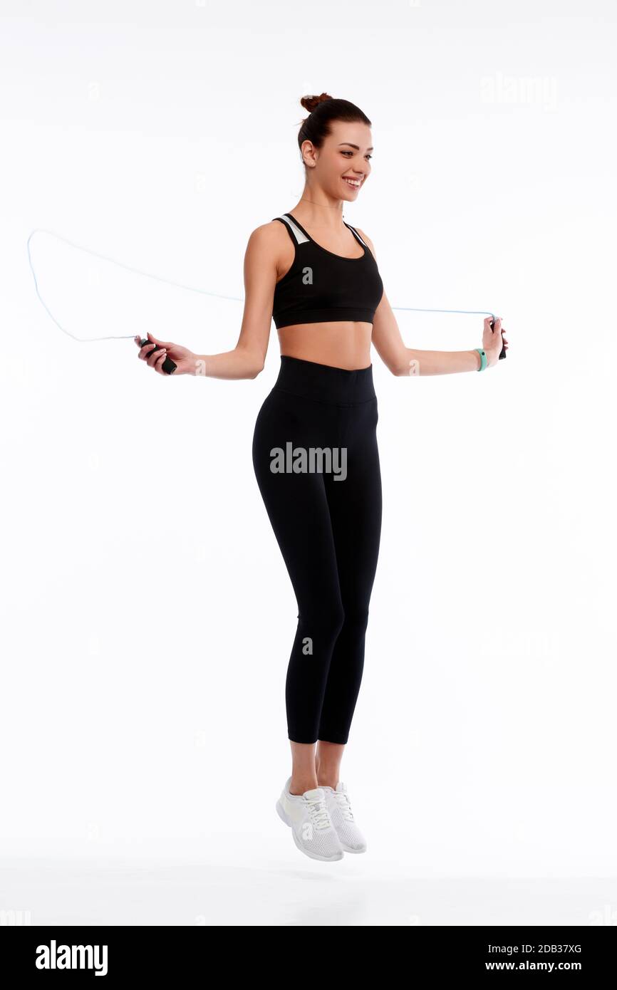 Spotrswoman jumping with rope on white isolate background. Fitness ...