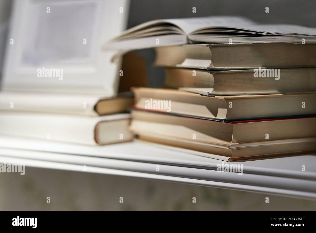 Book shelf with books in piles and rows Stock Photo - Alamy