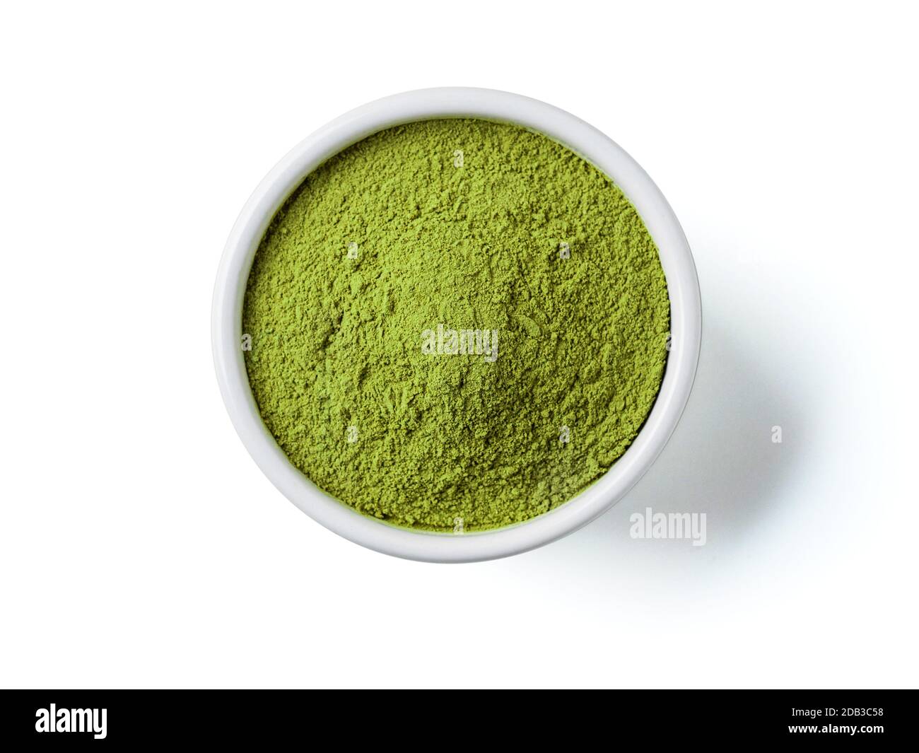Green matcha tea powder in small white bowl on white background ...