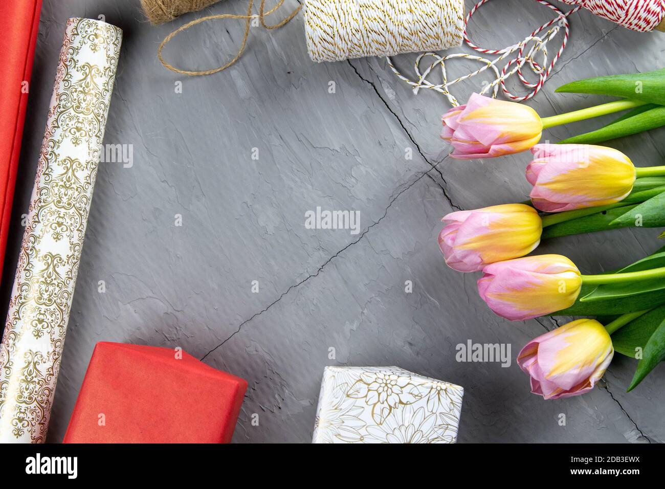 Preparing for the packaging of gifts, on the table laid out red and ...