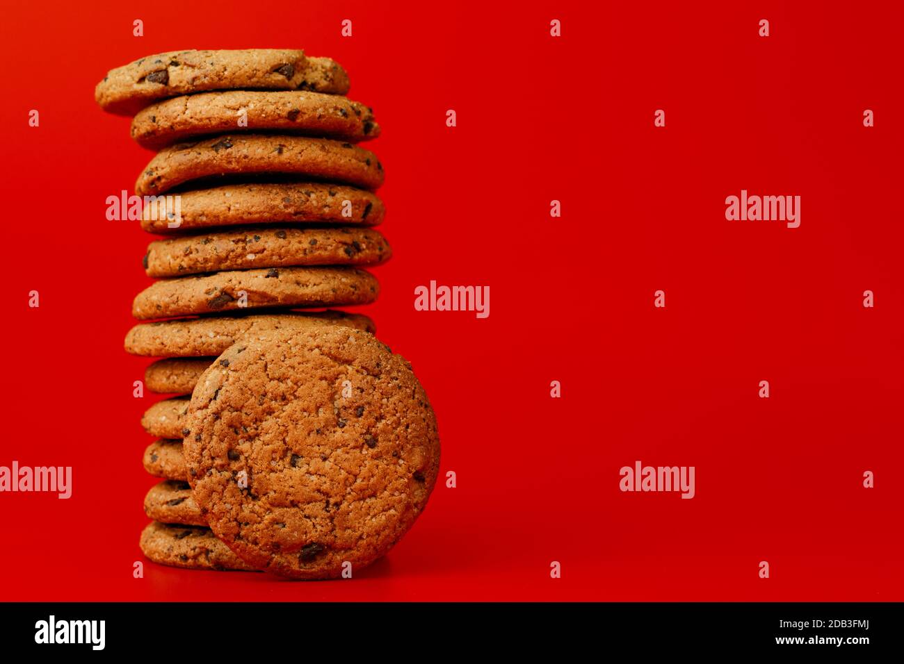 Chocolate chip cookies in stack on red background Stock Photo - Alamy