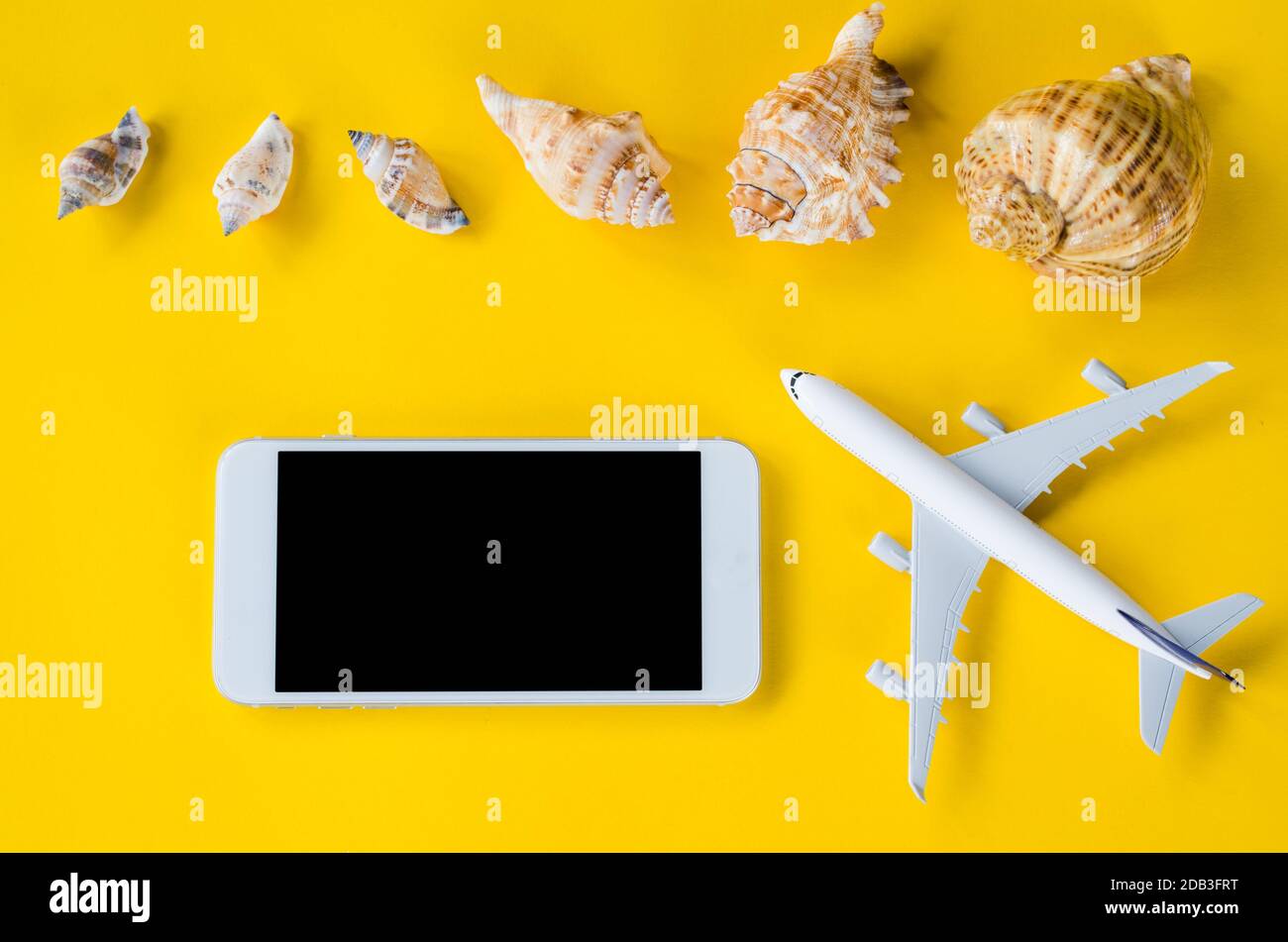 Empty screen smartphone, decorative airplane and seashells, template ...