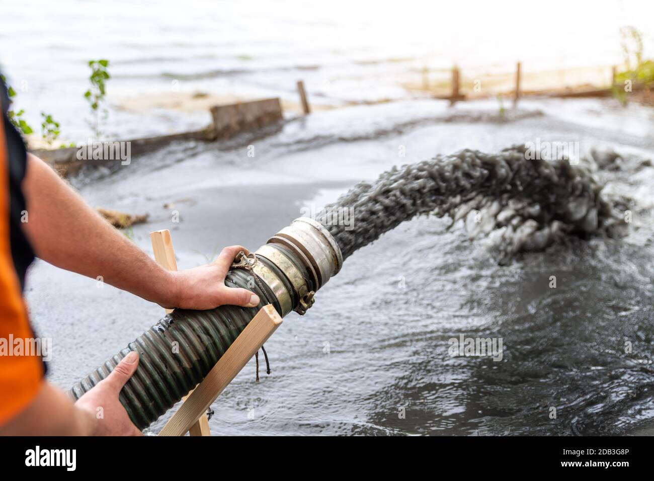 Engeneer hold pipe of power pump machine pouring mud sludge waste water ...
