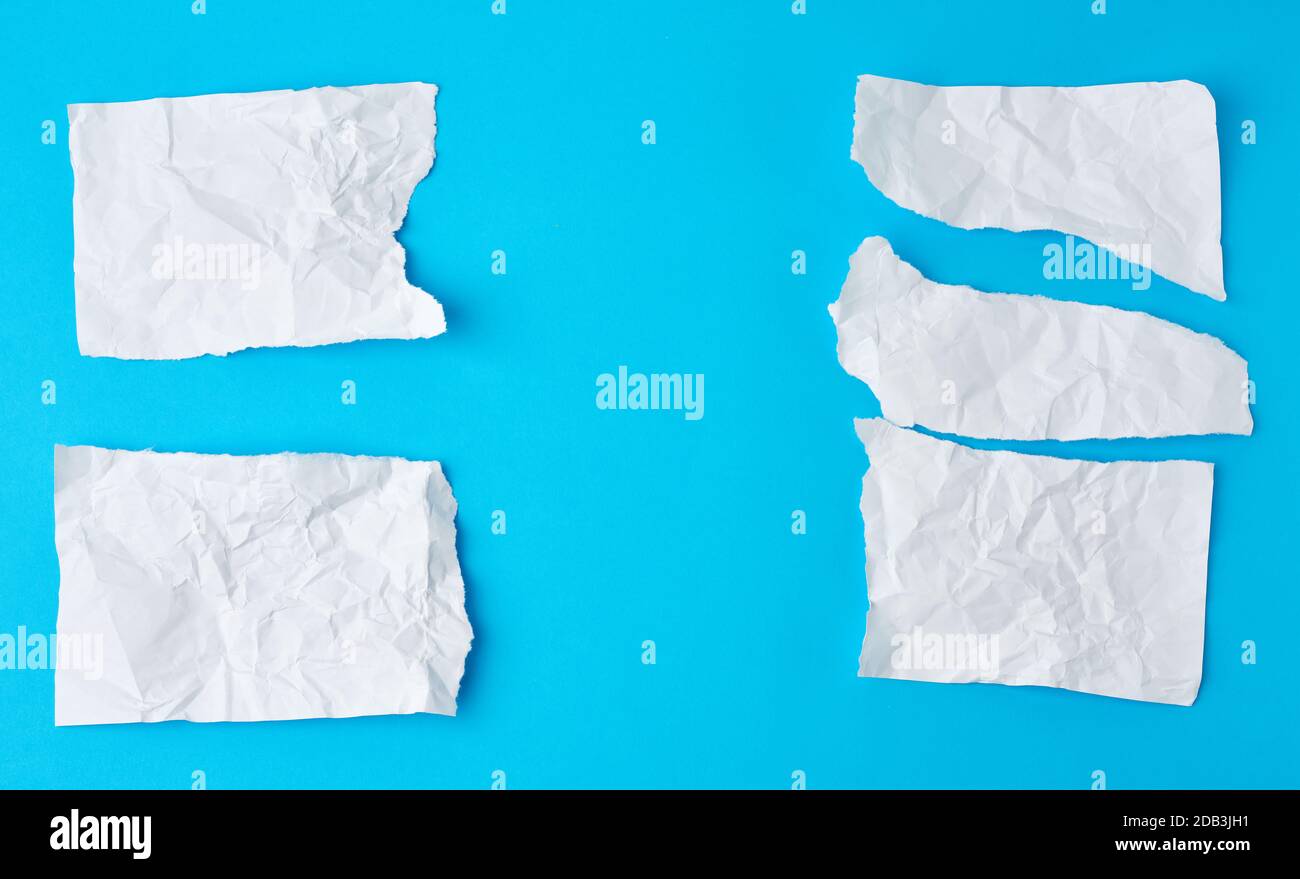 crumpled white sheet of paper torn on a blue background. Paper piece ...