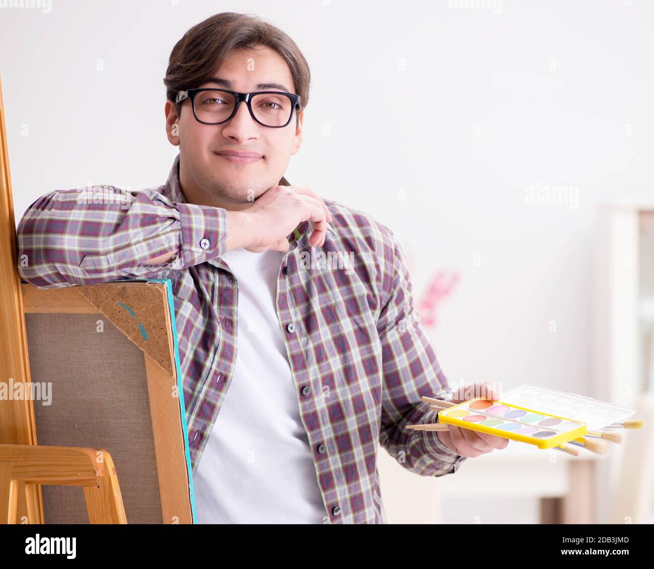 The young male artist drawing pictures in bright studio Stock Photo - Alamy