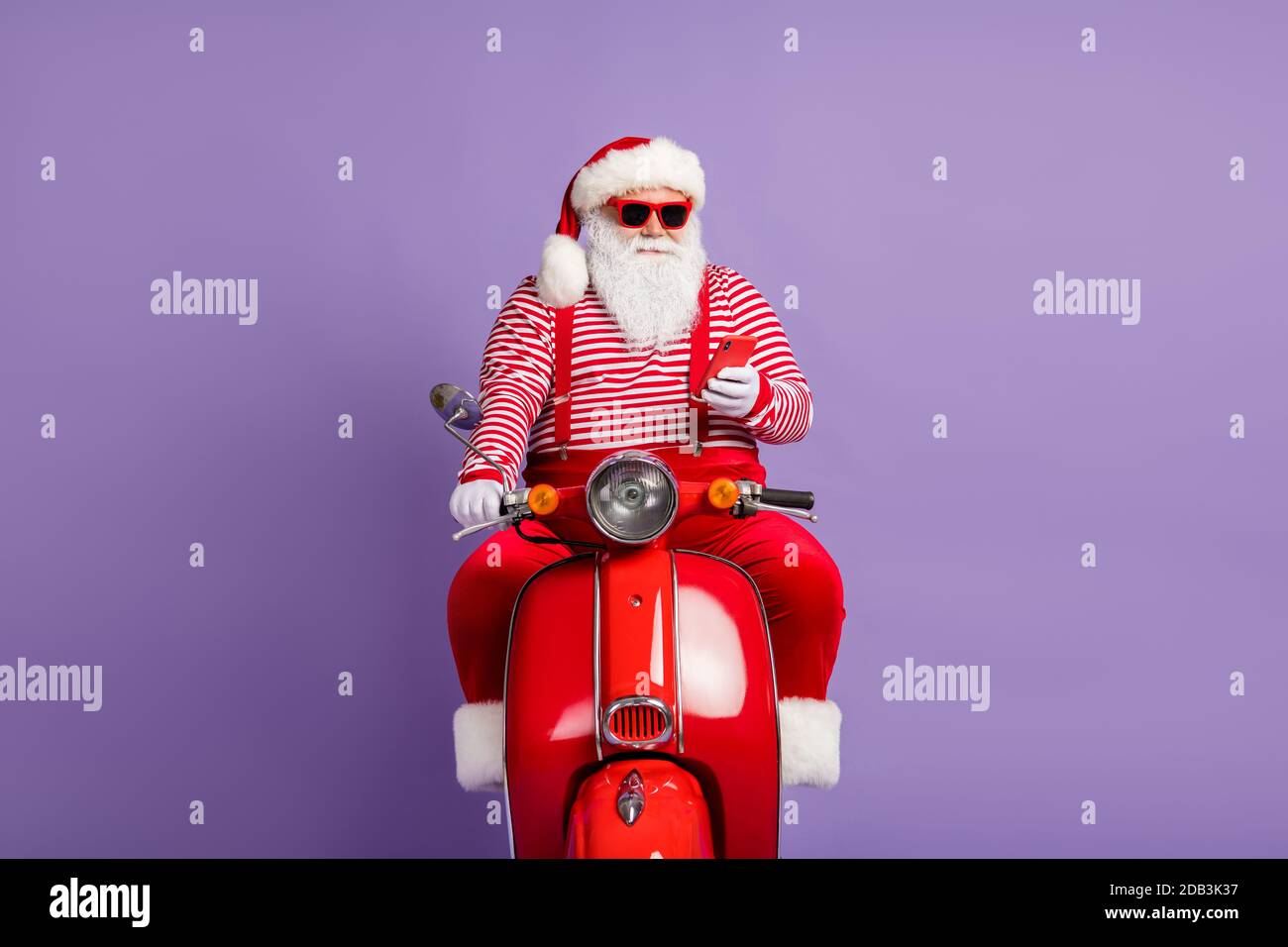 Photo of cheerful santa drive bike hold telephone look screen wear x ...