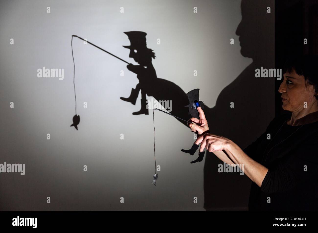 play shadow projected on a white screen. the person's hands shape a ...