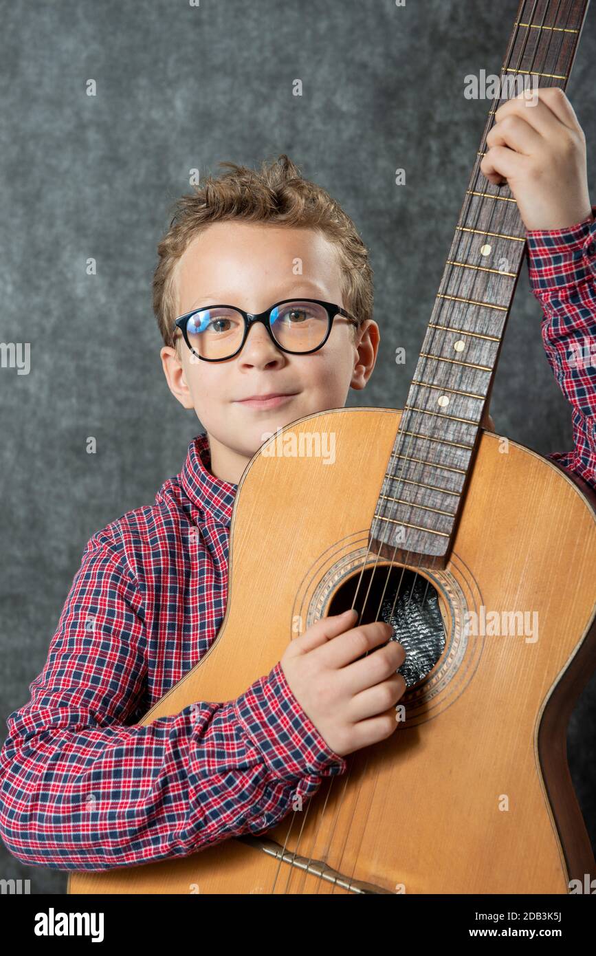 a funny boy playing on acoustic guitar Stock Photo - Alamy