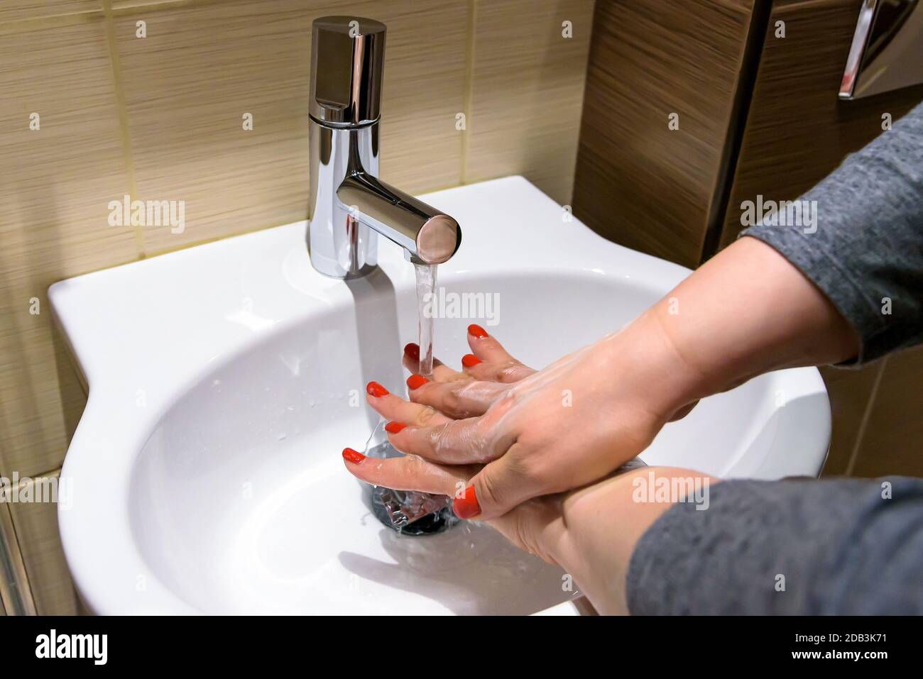 A woman is soaping her hands with soap under running water Stock Photo ...