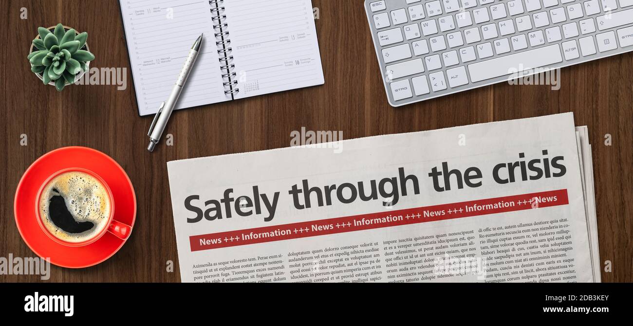 Newspaper on a desk - Safely though the crisis Stock Photo - Alamy