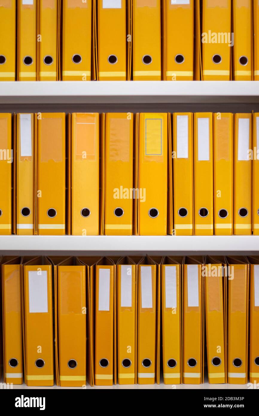 Aligned yellow binders on a office space Stock Photo - Alamy