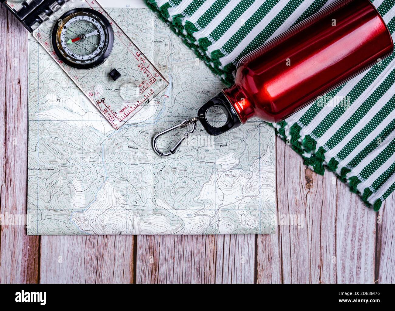The flat lay of hiking equipment - map, bottle, and compass Stock Photo ...