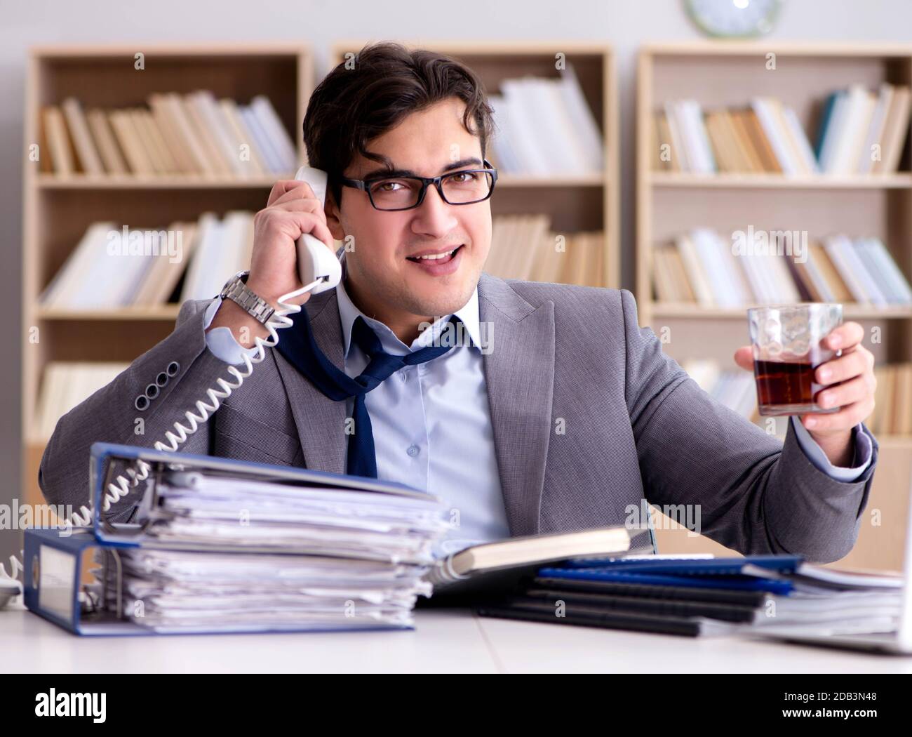 The young businessman drinking from stress Stock Photo - Alamy