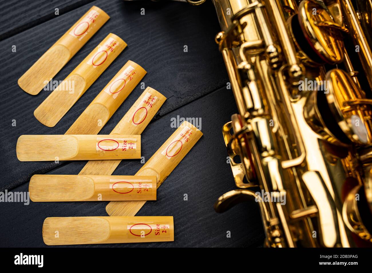 Reeds of a mouthpiece of a saxophone and a bright golden saxophone on ...