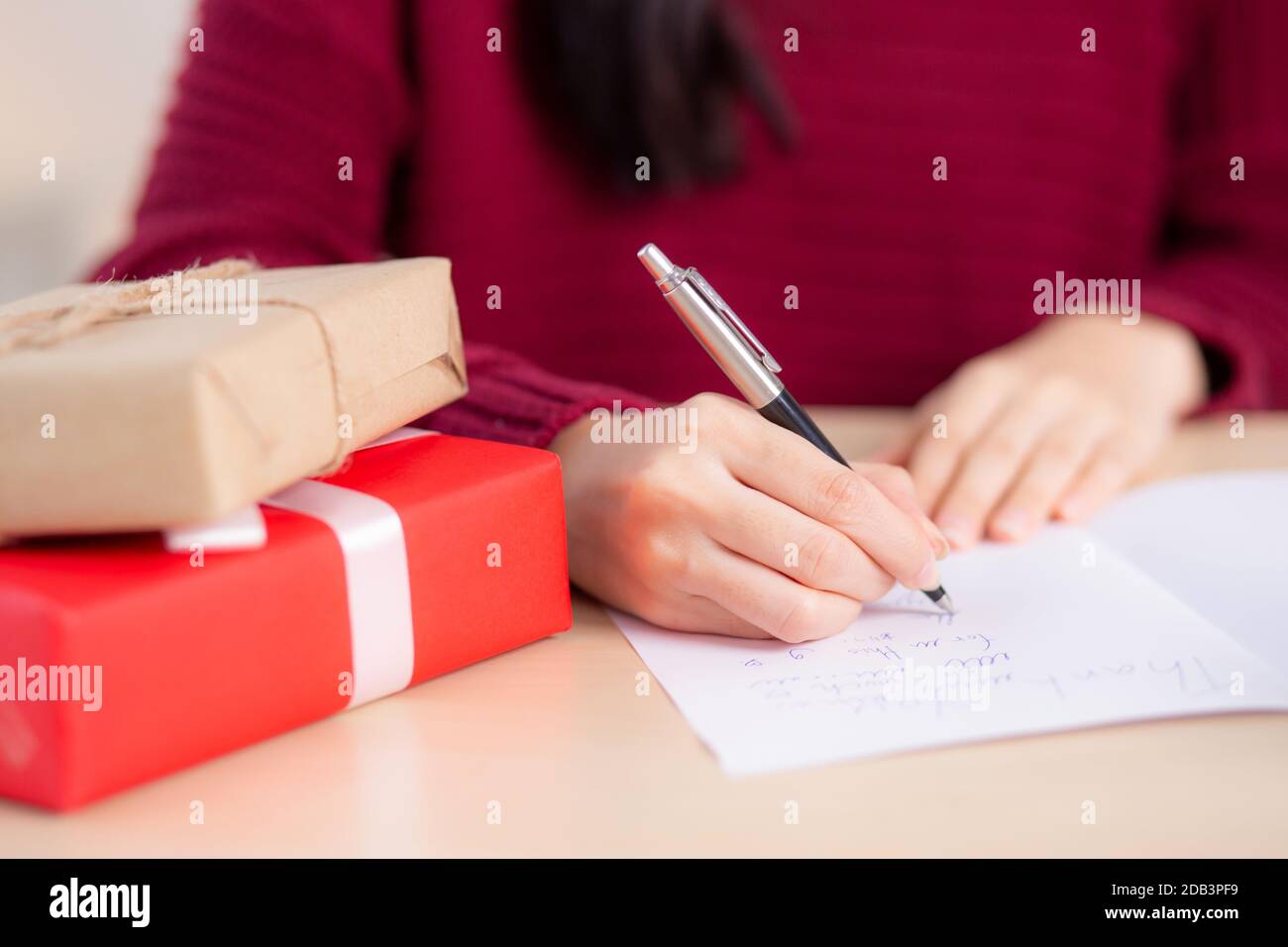 Closeup hand of young asian woman writing postcard in Christmas day at ...