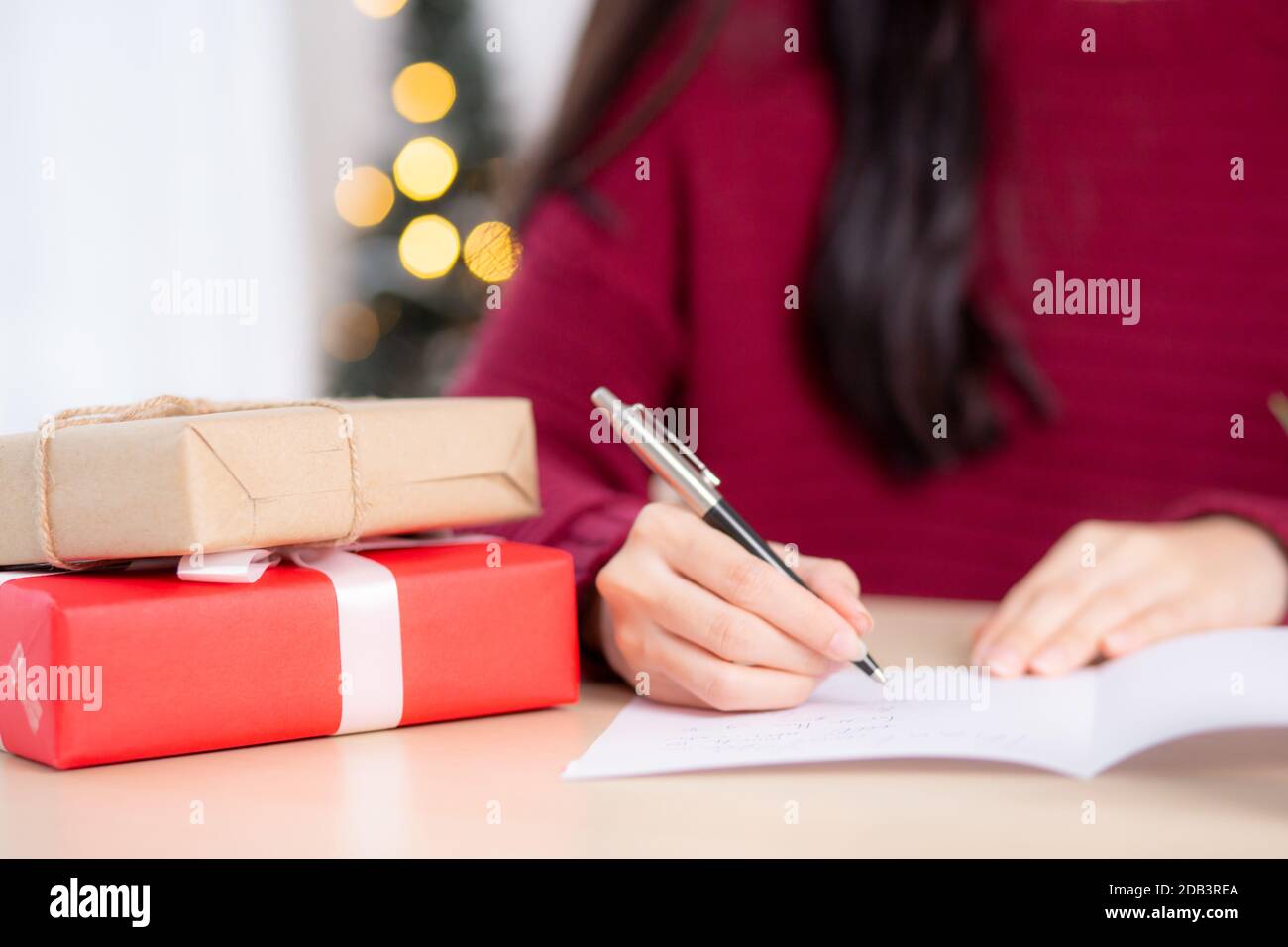 Closeup hand of young asian woman writing postcard in Christmas day at ...