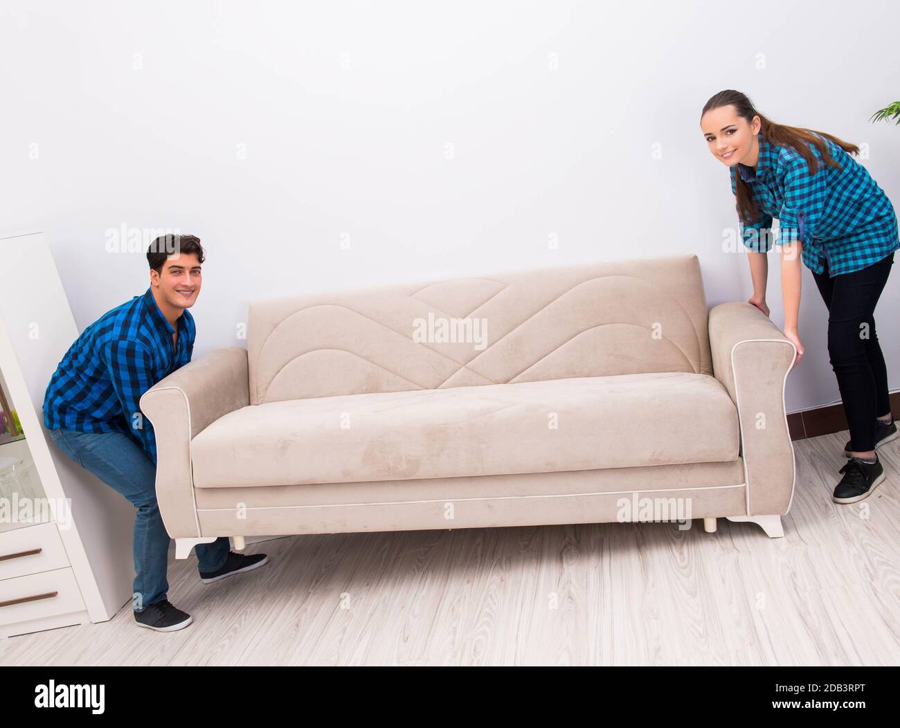 The wife and husband moving sofa couch Stock Photo - Alamy