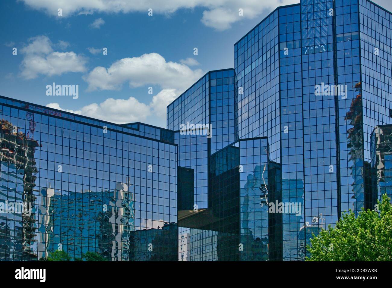 A blue glass financial center reflecting city Stock Photo - Alamy