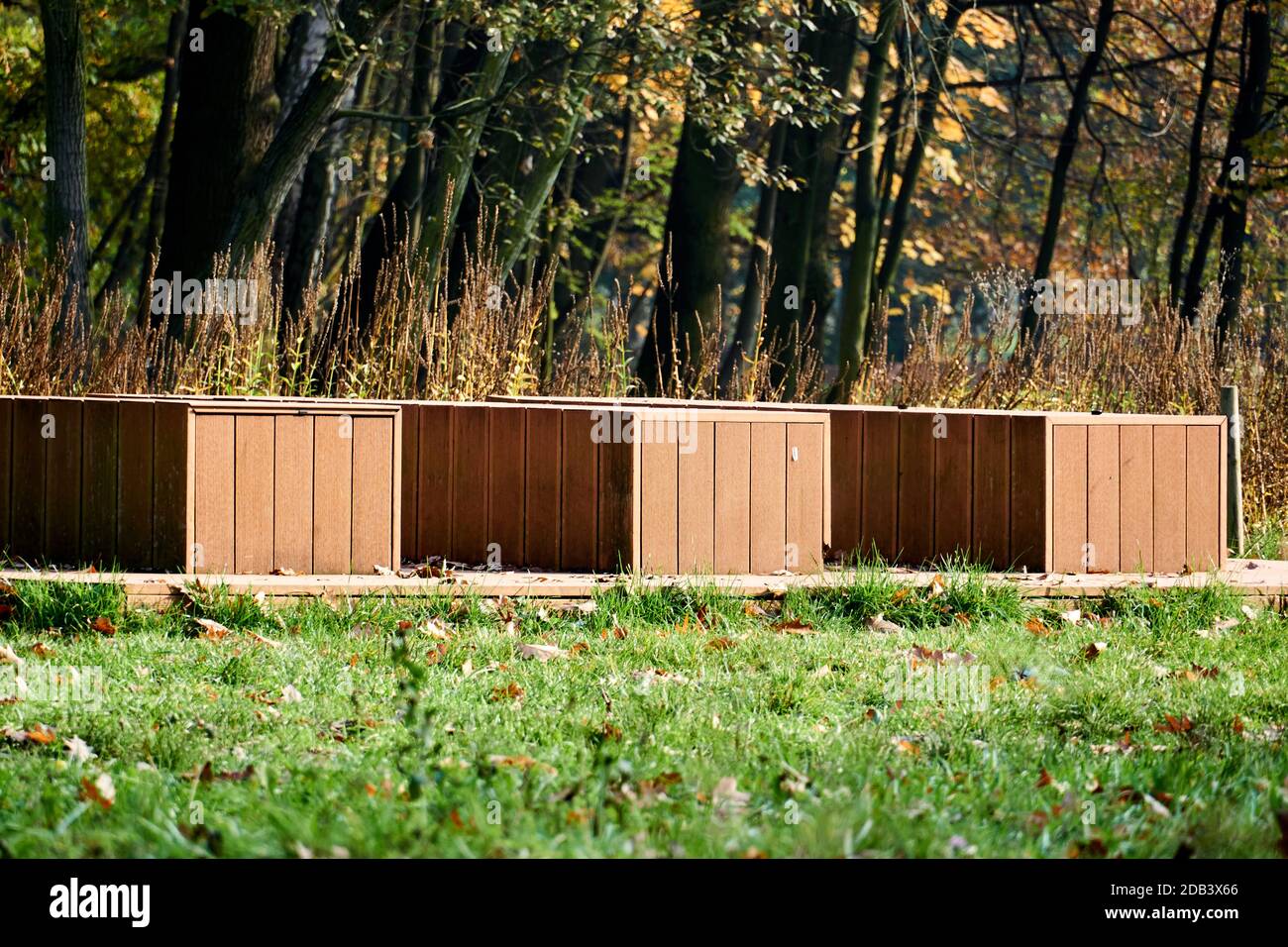 Three wooden block benches surrounded by trees in a park under the ...
